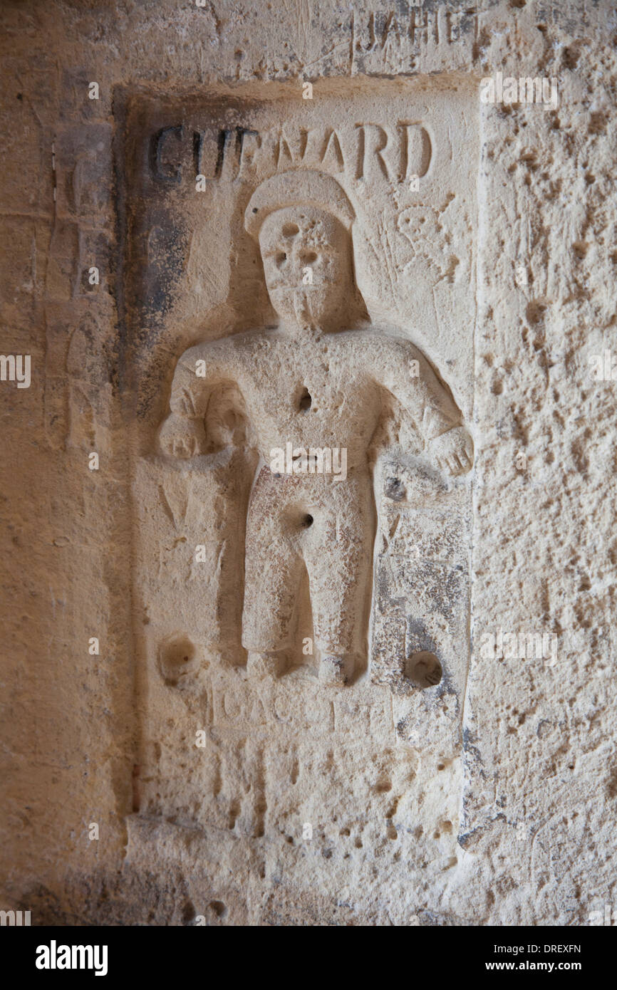 Close up of a carving of a person and message on a stone wall of the ...