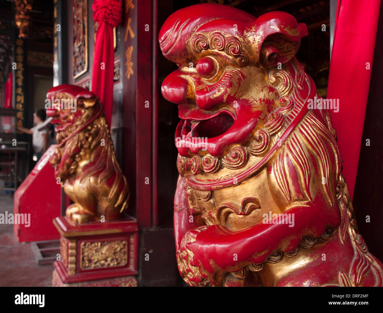 Two grotesque red and gold figures stand guard beside the door of a ...