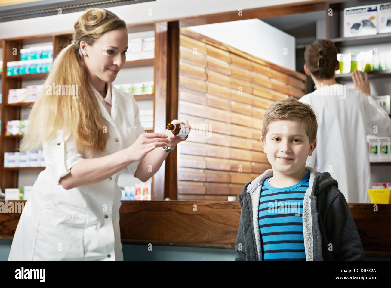 Female Pharmacist Giving Boy Cough Syrup, Munich, Bavaria, Germany ...