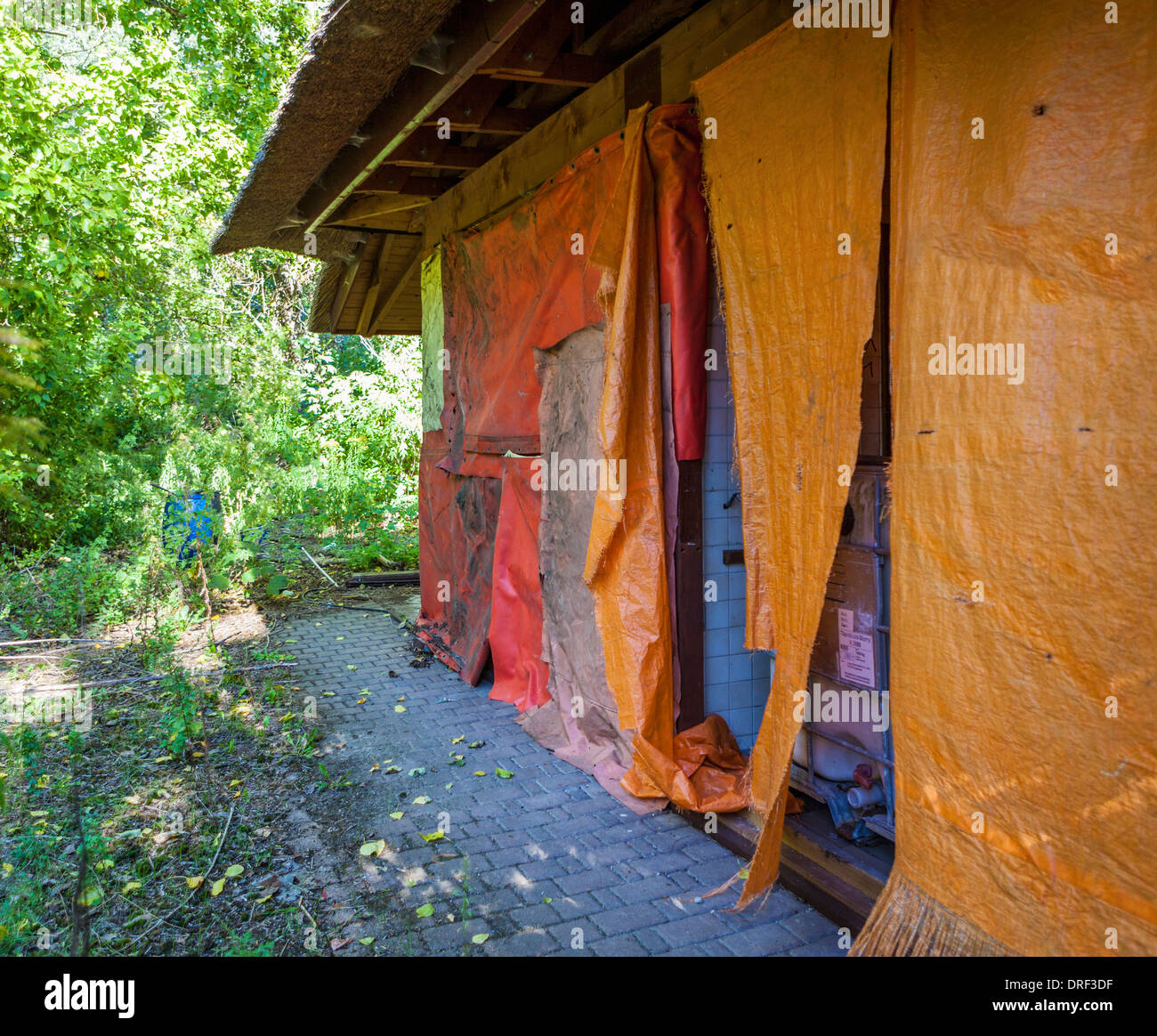 Old building covered in tattered canvas at derelict, abandoned, disused ...