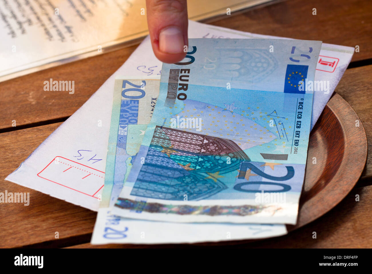 Dining check with Euro banknotes on wooden table Stock Photo - Alamy