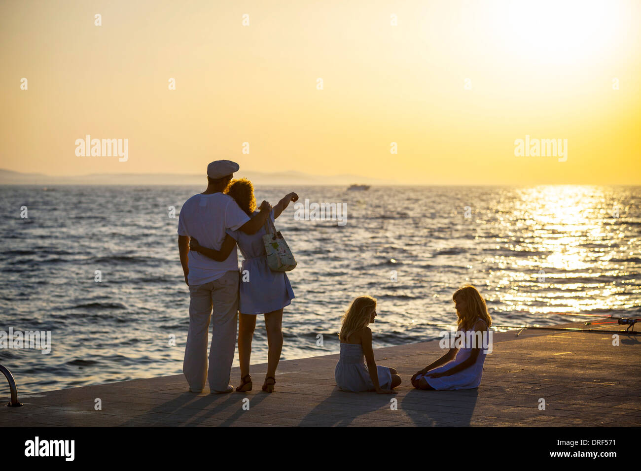 Family on the waterfront, looking at sunset, Zadar, Croatia Stock Photo ...