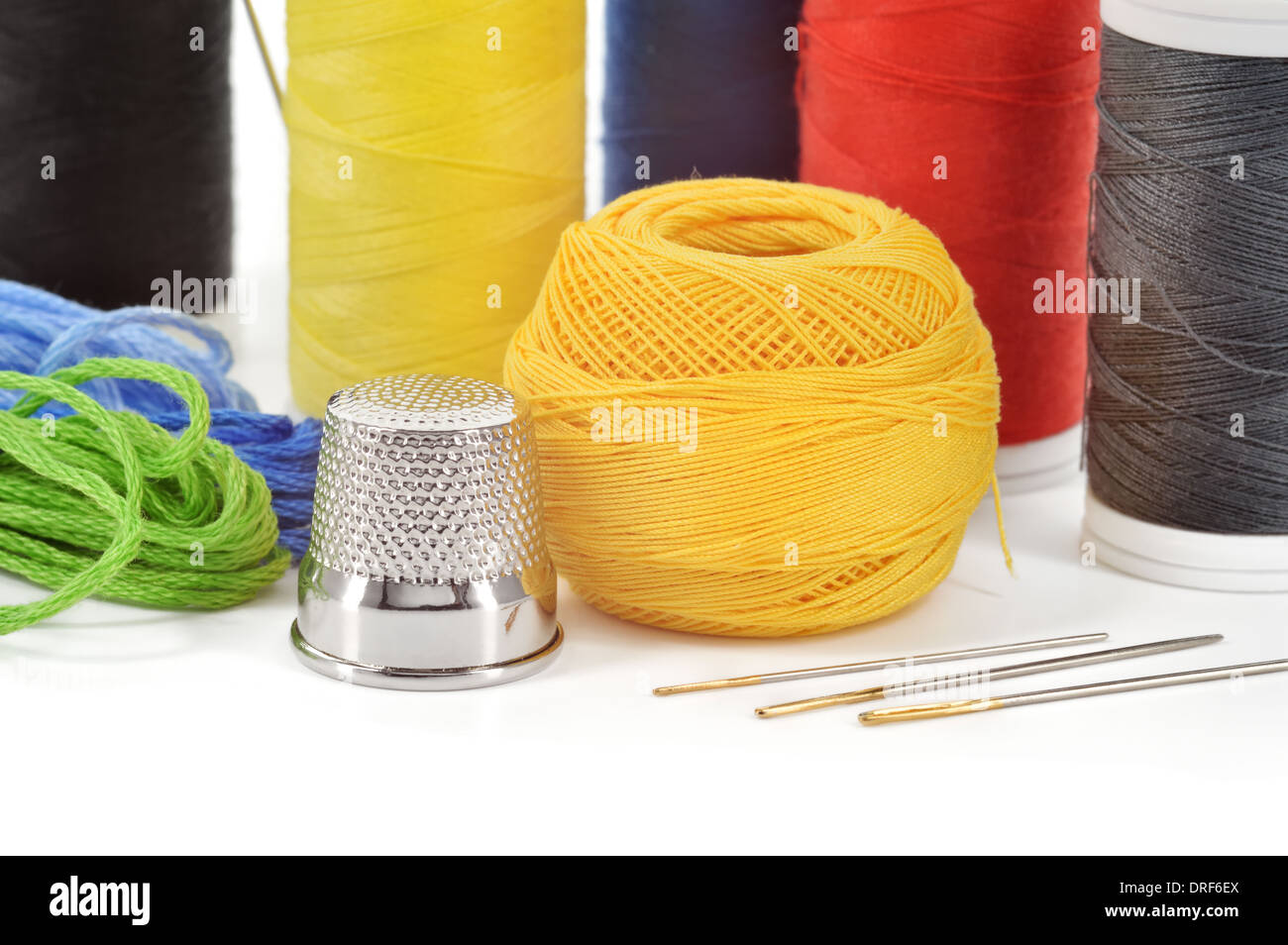 Sewing accessories. Few needles, threads and thimble isolated on white ...
