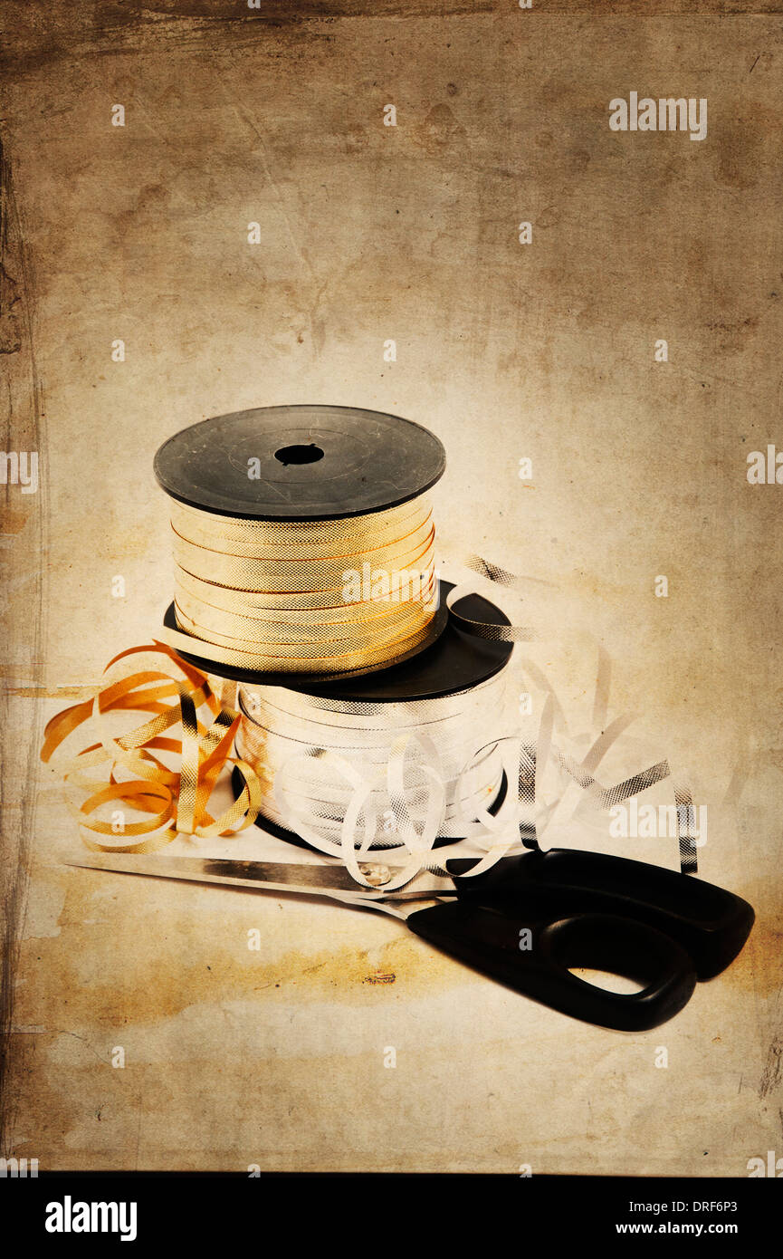 Still life of two spools of ribbon and a pair of scissors against ...