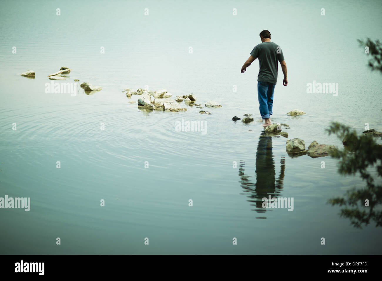 Colorado USA man walking barefoot across stepping stones lake Stock ...