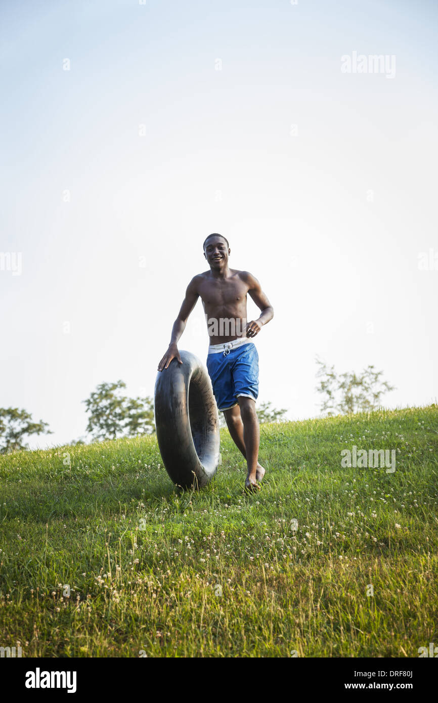 Maryland USA teenage boy running rolling swim float black tyre Stock ...