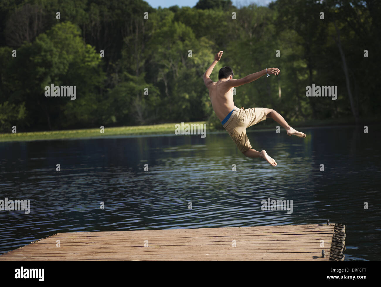 New York state USA boy running jumping into water from wooden jetty ...