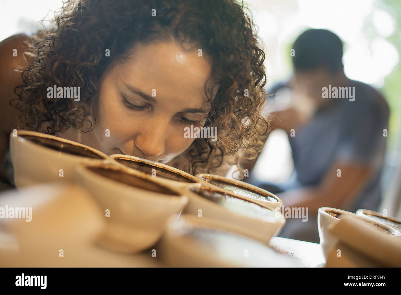 New York state USA woman sampling in organic coffee processing shed ...