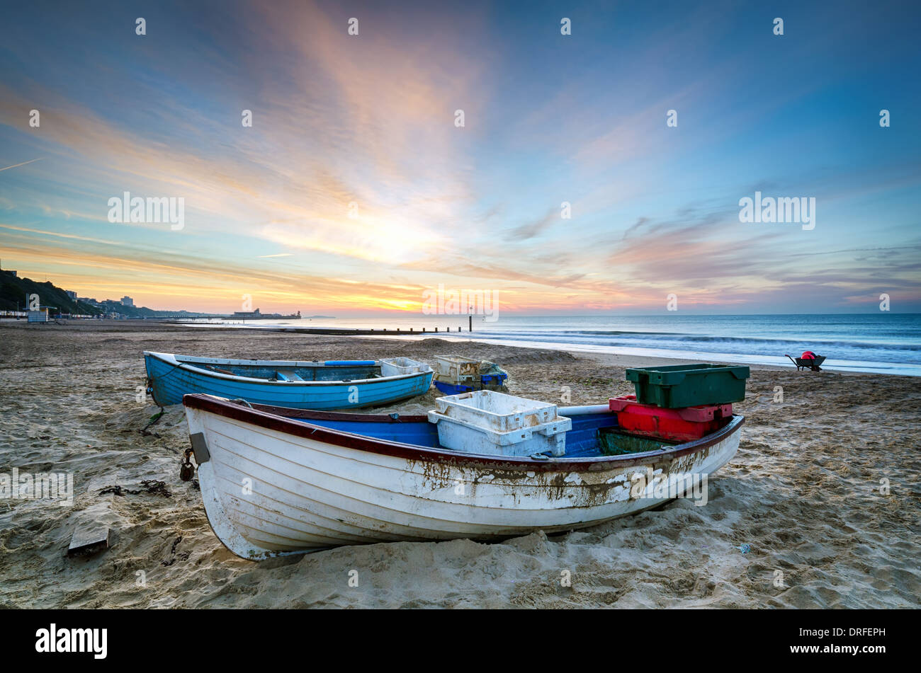 Fishing boats on the beach at sunrise on Bournemouth beach with pier in ...