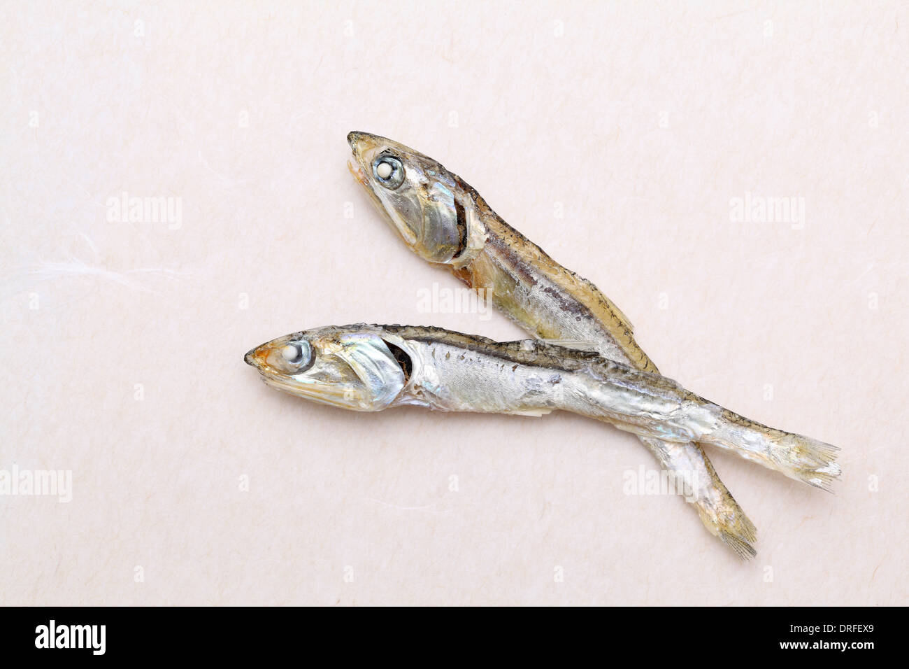 Dried small fish used in japanese cuisine, on japanese paper background ...