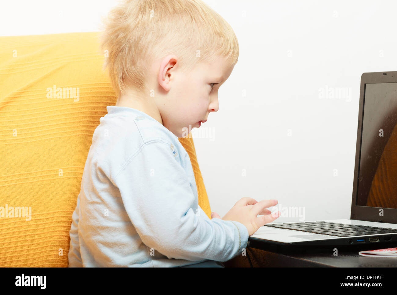 Happy childhood. Blond boy child kid preschooler playing on laptop ...
