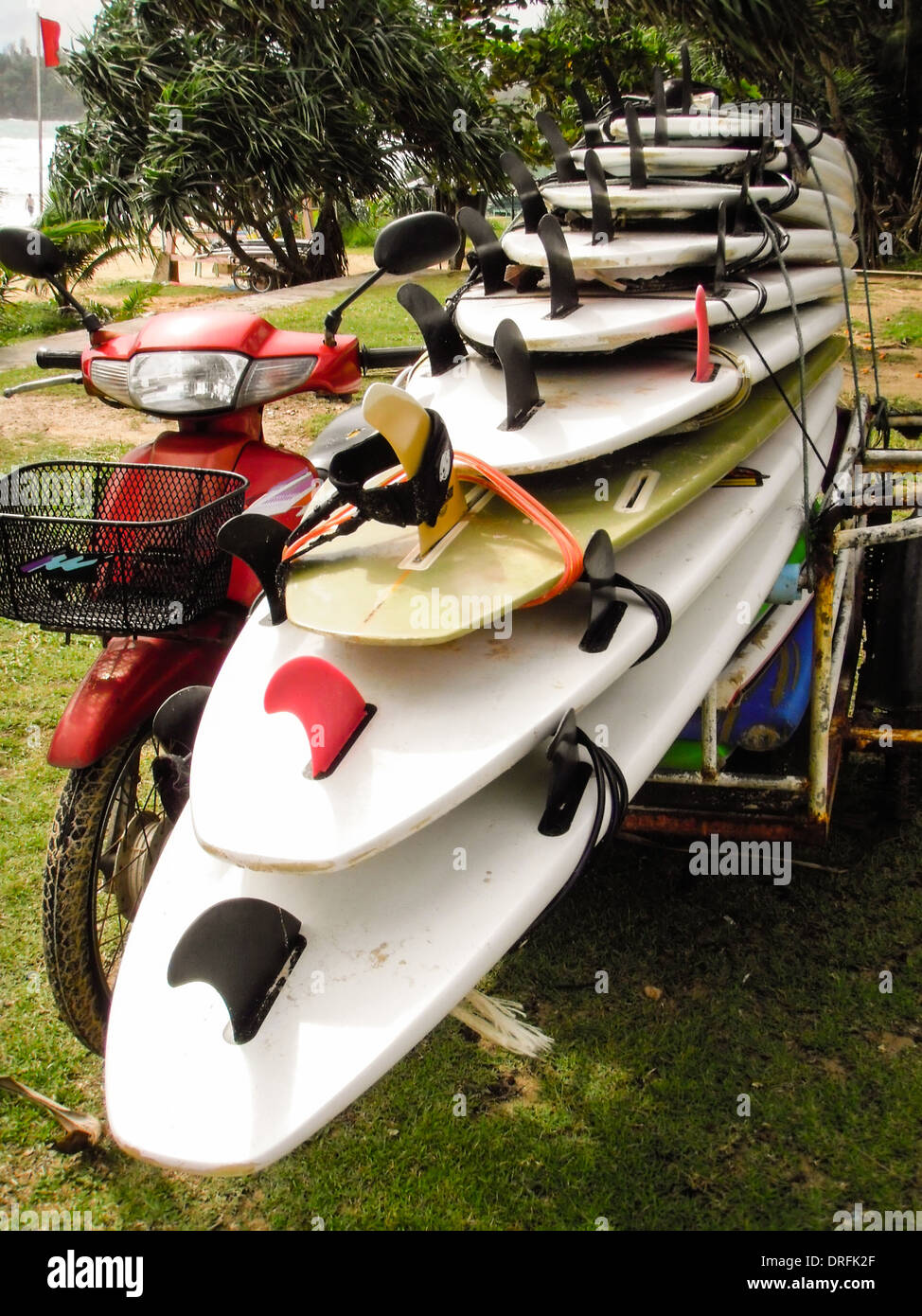different sizes of surfboards are loaded on a scooter. ready to ...