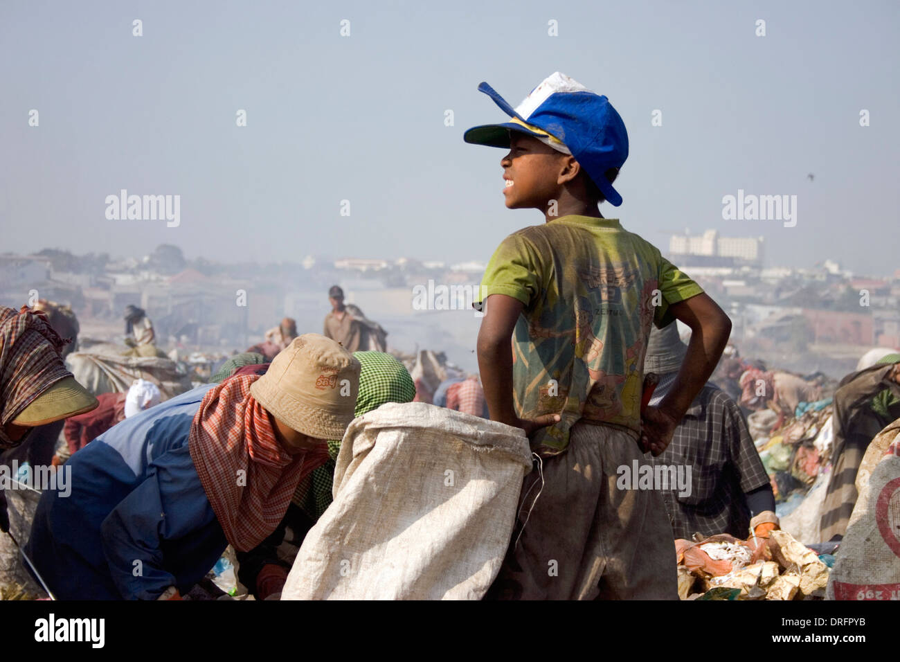 A young child laborer boy is looking at the dump site at the toxic ...