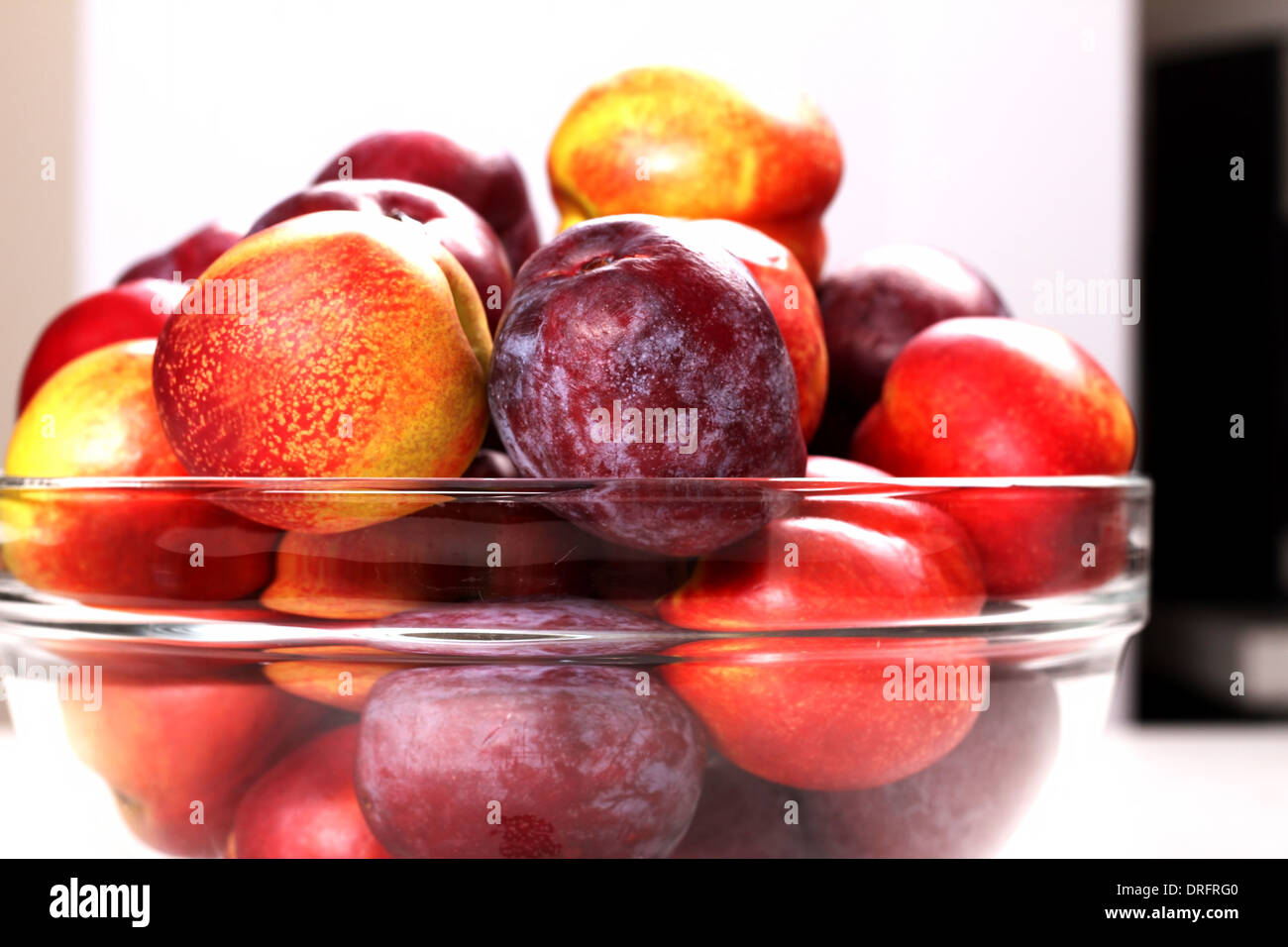Nectarines and Plums in a glass bowl, close up Stock Photo - Alamy
