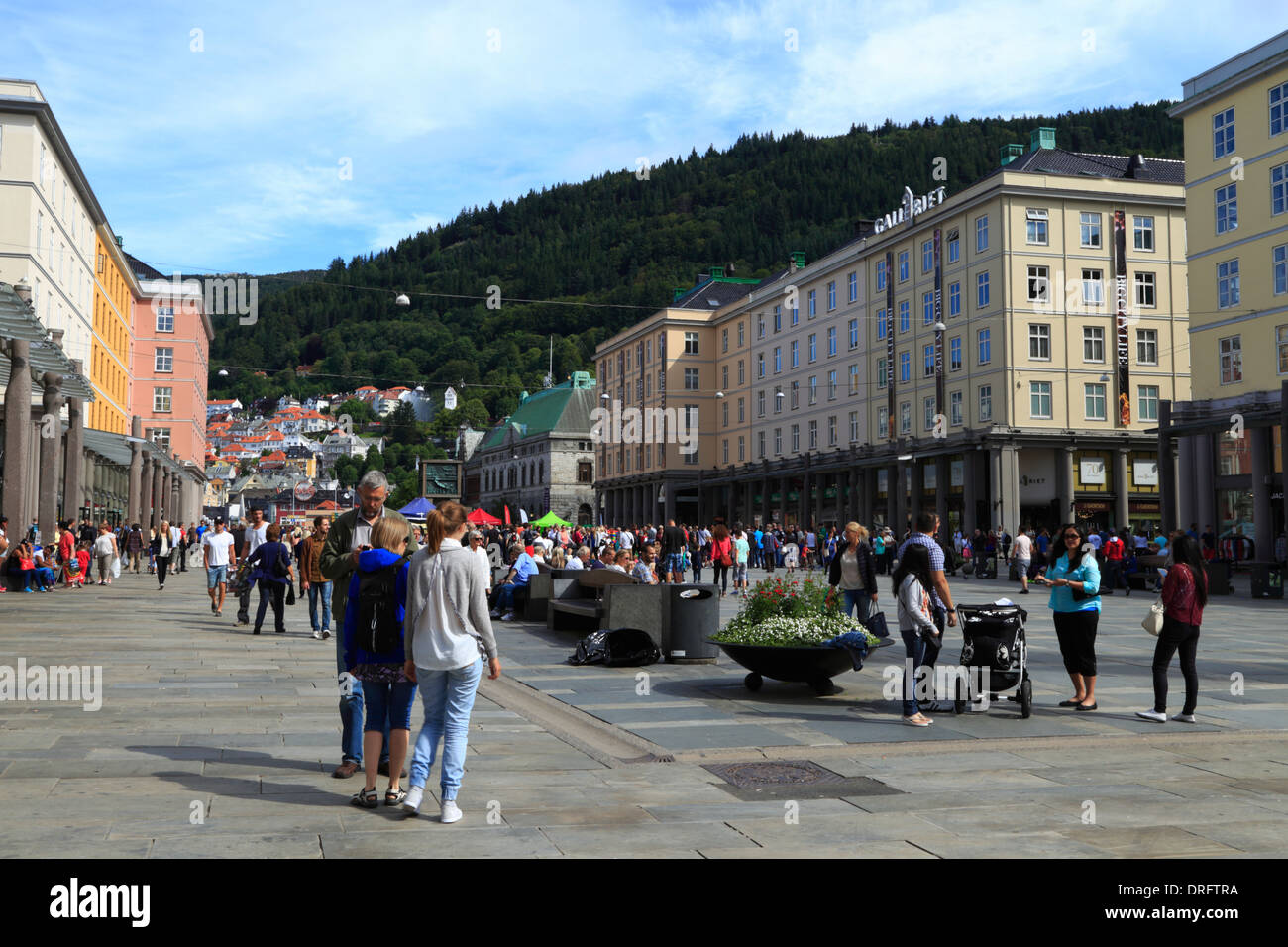 People stand and walk alongTorgallmenningen, the main square, in Bergen ...