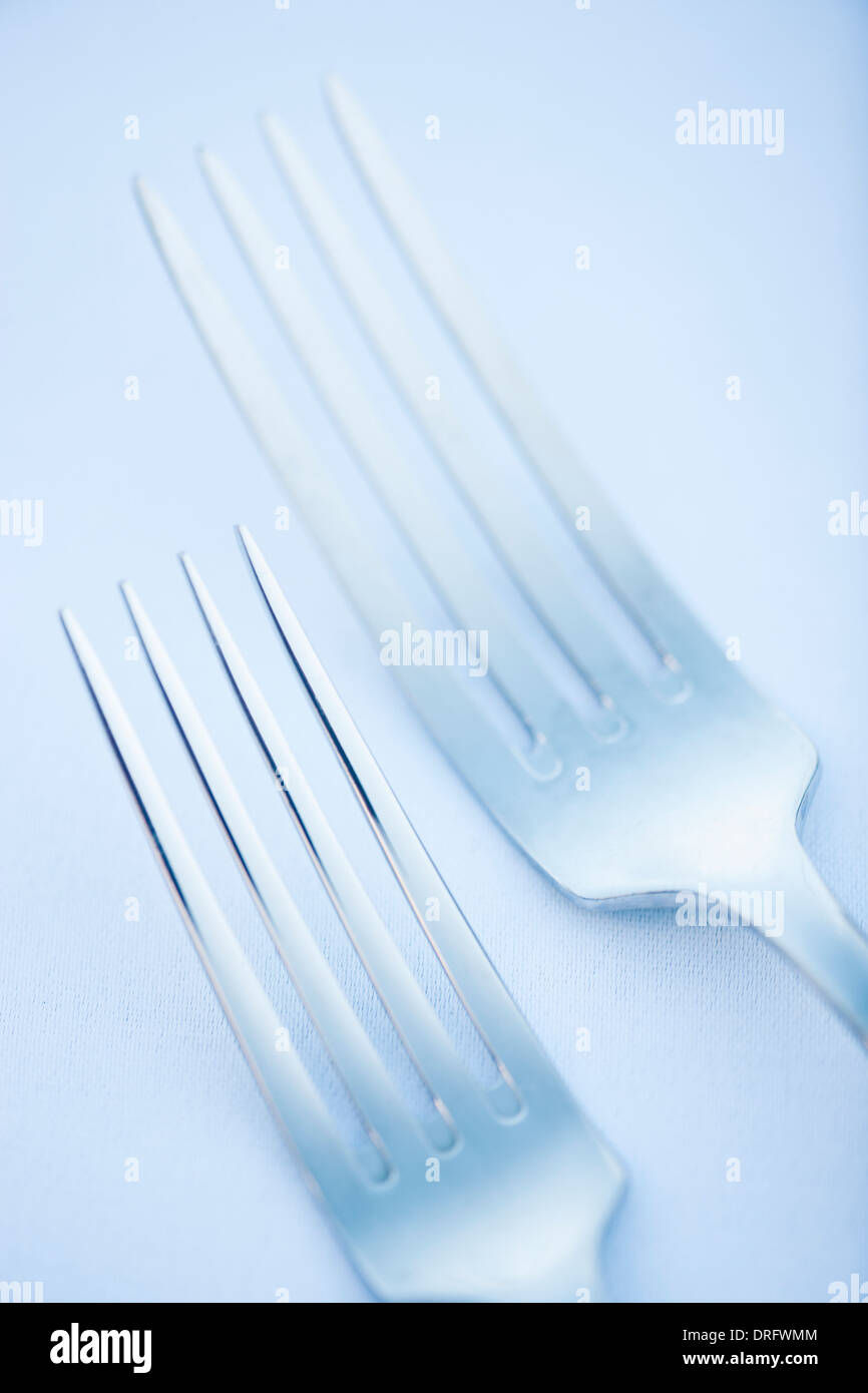 Two forks against white background Stock Photo - Alamy