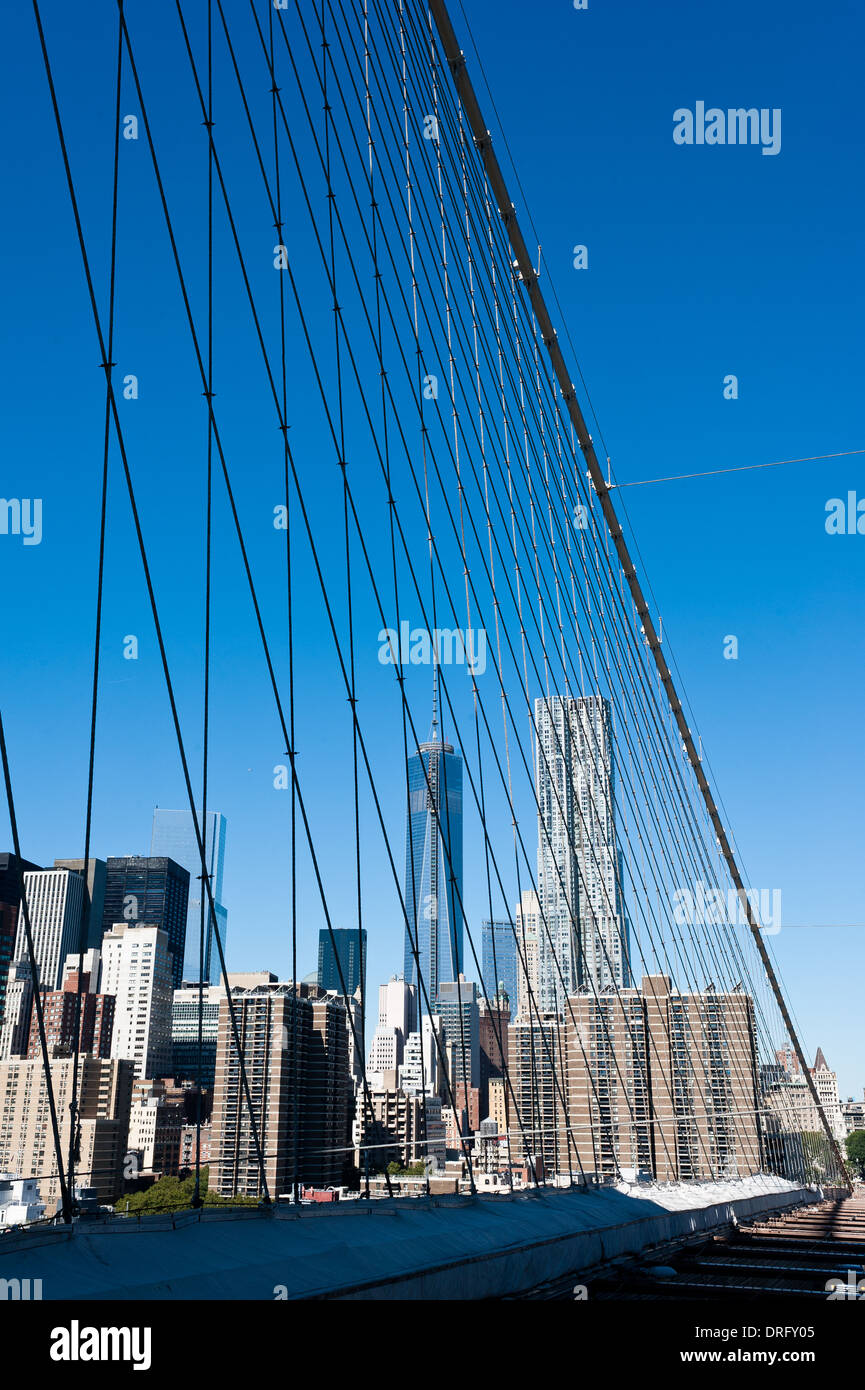 A view through the wire supports of the Brooklyn bridge with the ...