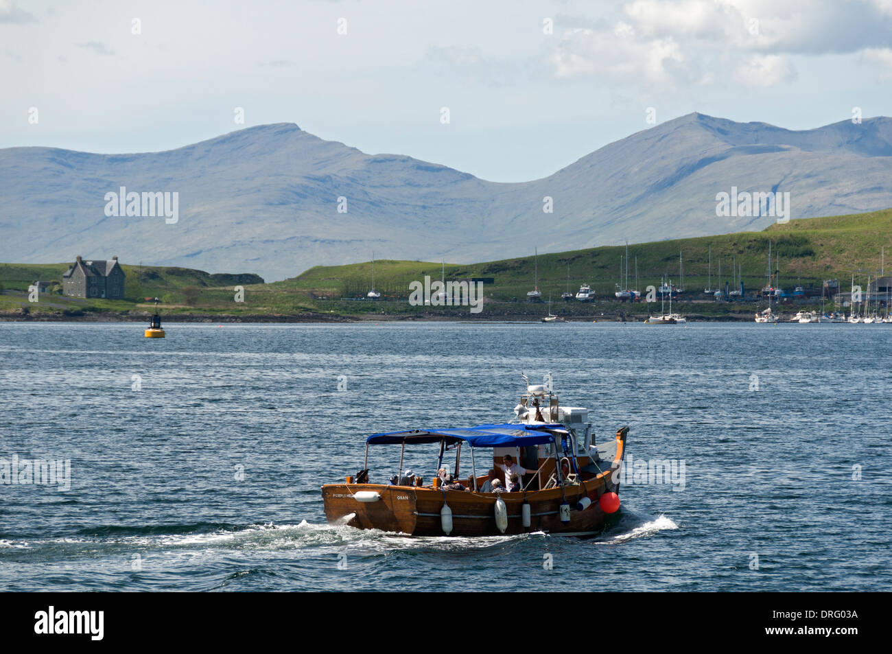 A tour boat in Oban Bay with the hills of Mull behind. Oban, Highland ...