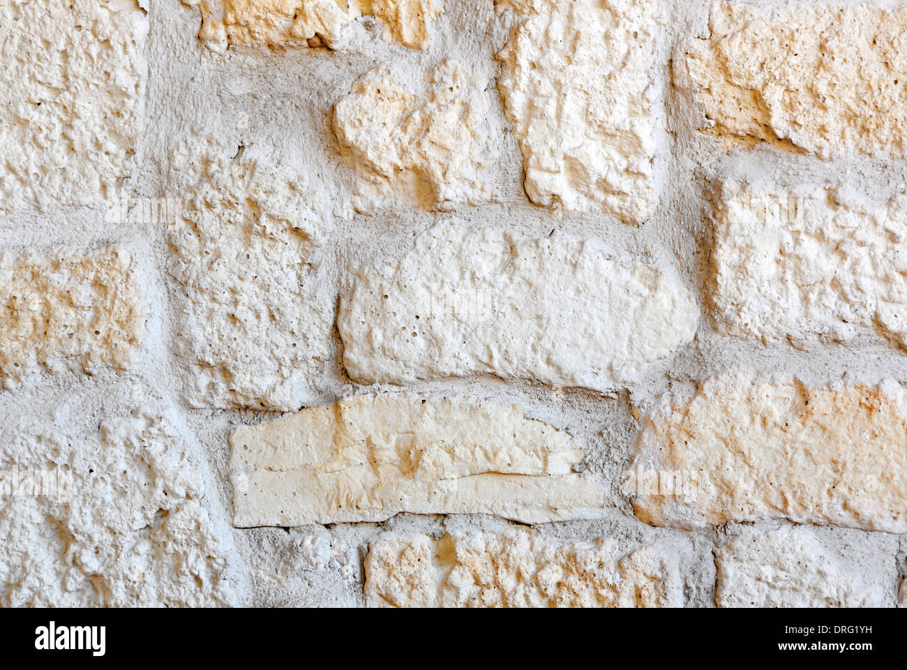 Wall lined with light yellow porphyry stones Stock Photo - Alamy