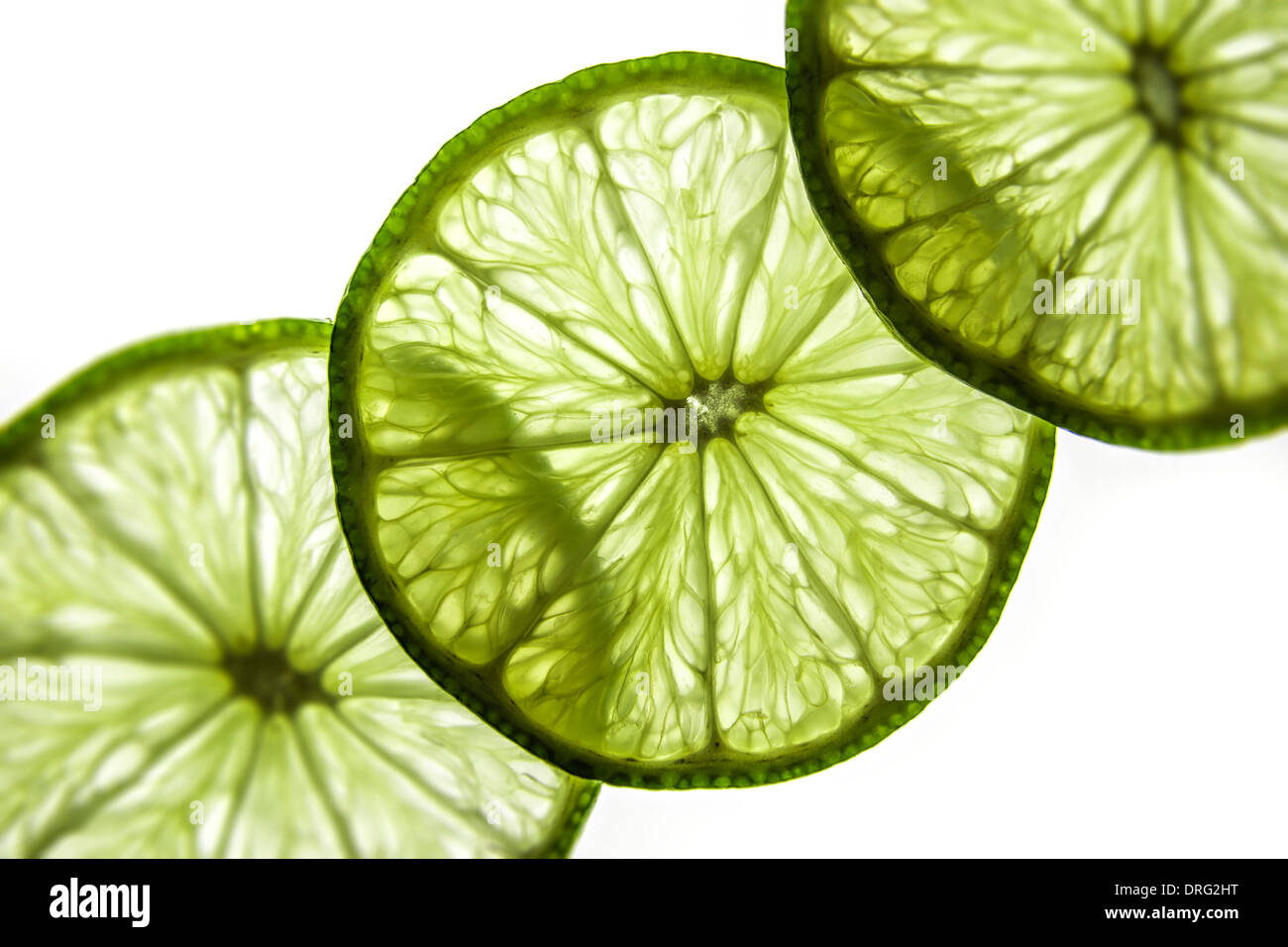 Slices of a lime on illuminated white background Stock Photo - Alamy