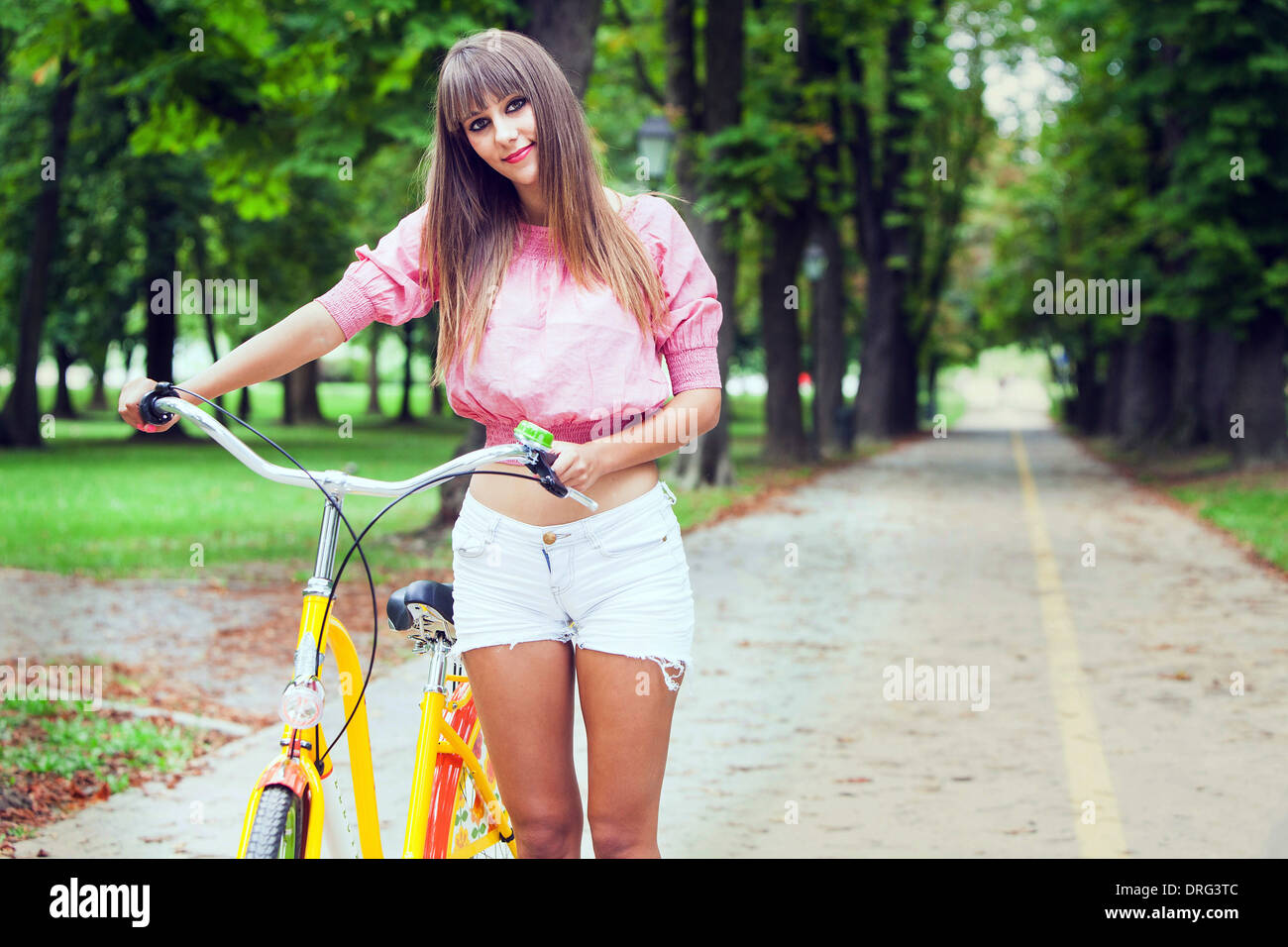 Young woman pushing bicycle in a park, Osijek, Croatia Stock Photo - Alamy