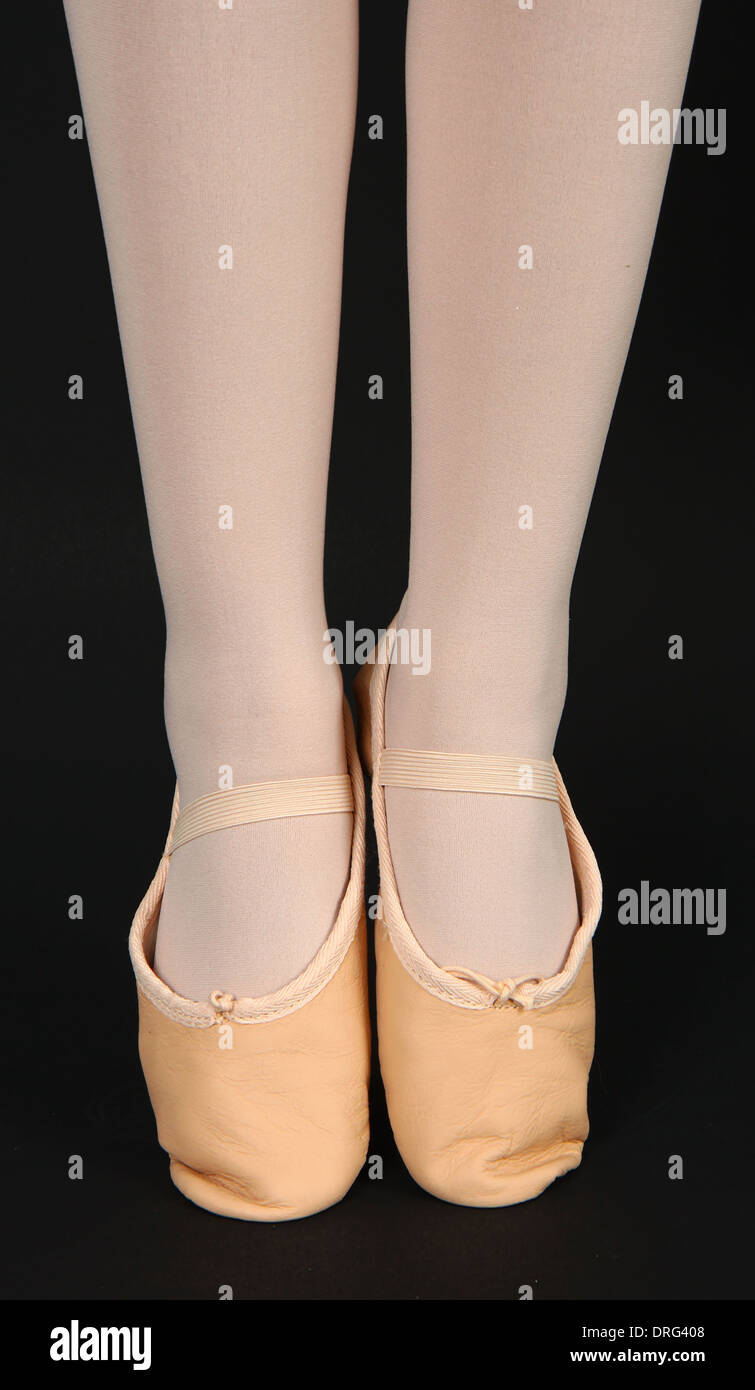 Detail of the feet of a dancer with demi-pointe on black background ...