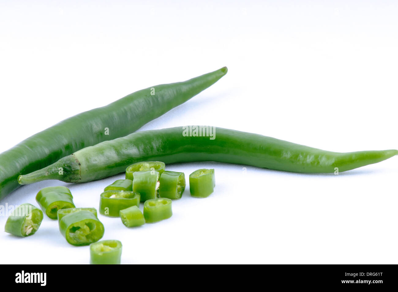 whole and chopped chillies on white background. closeup studio shot ...