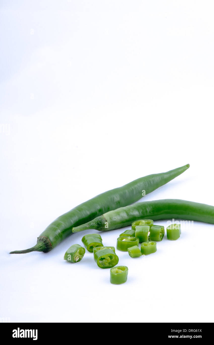 whole and chopped chillies on white background. vertical studio shot ...