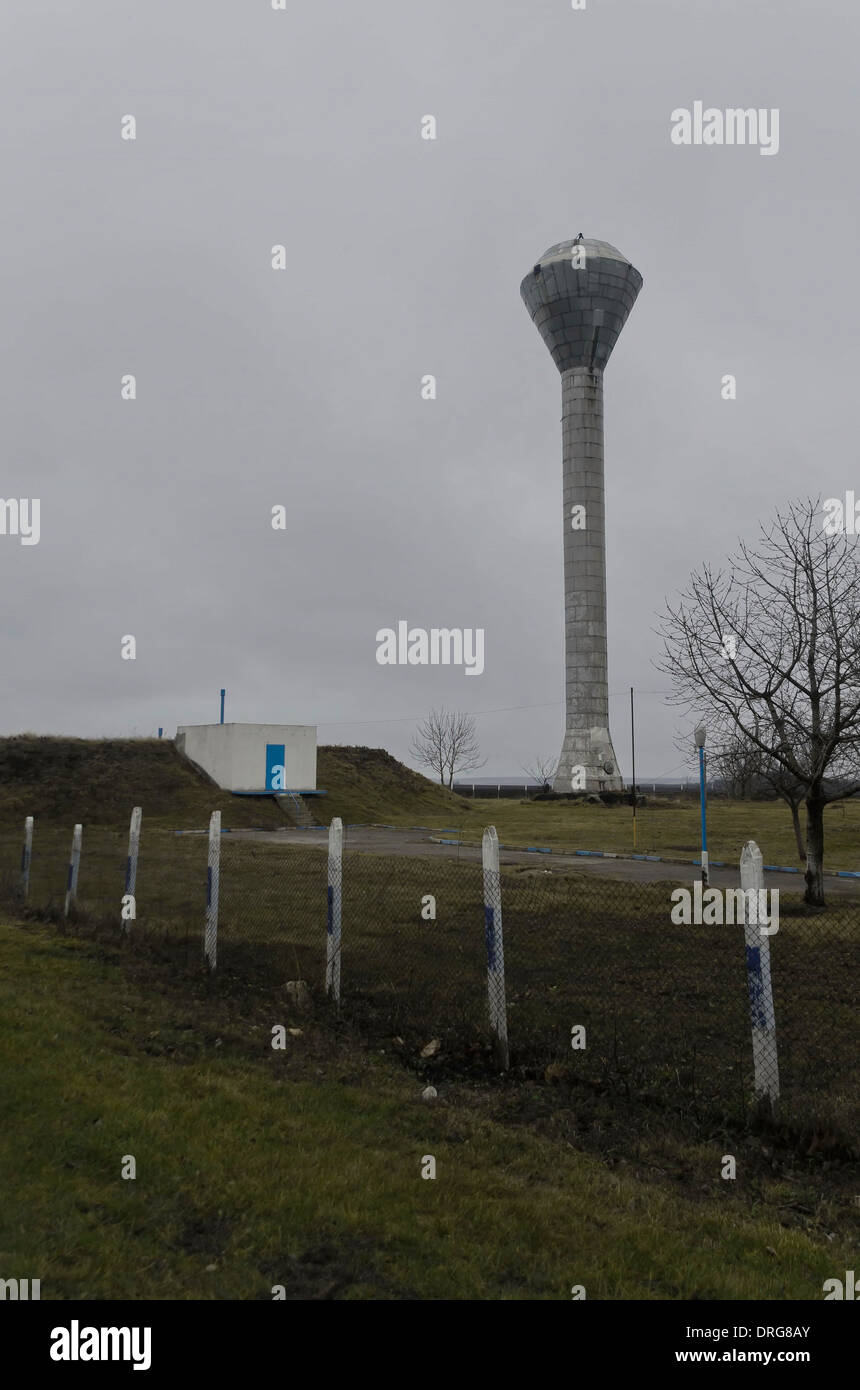 The orderly slender figure of a water storage tank and area on a misty ...