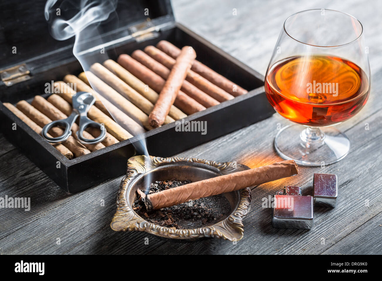 Aroma floating up from cigar and cognac in glass Stock Photo - Alamy