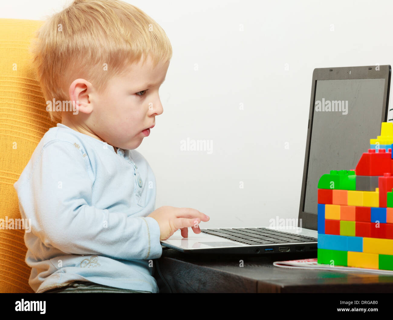 Happy childhood. Blond boy child kid preschooler playing on laptop ...