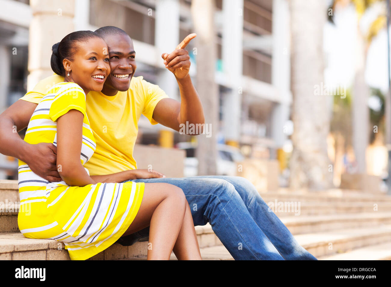 happy African American couple sitting outdoors in the city Stock Photo ...