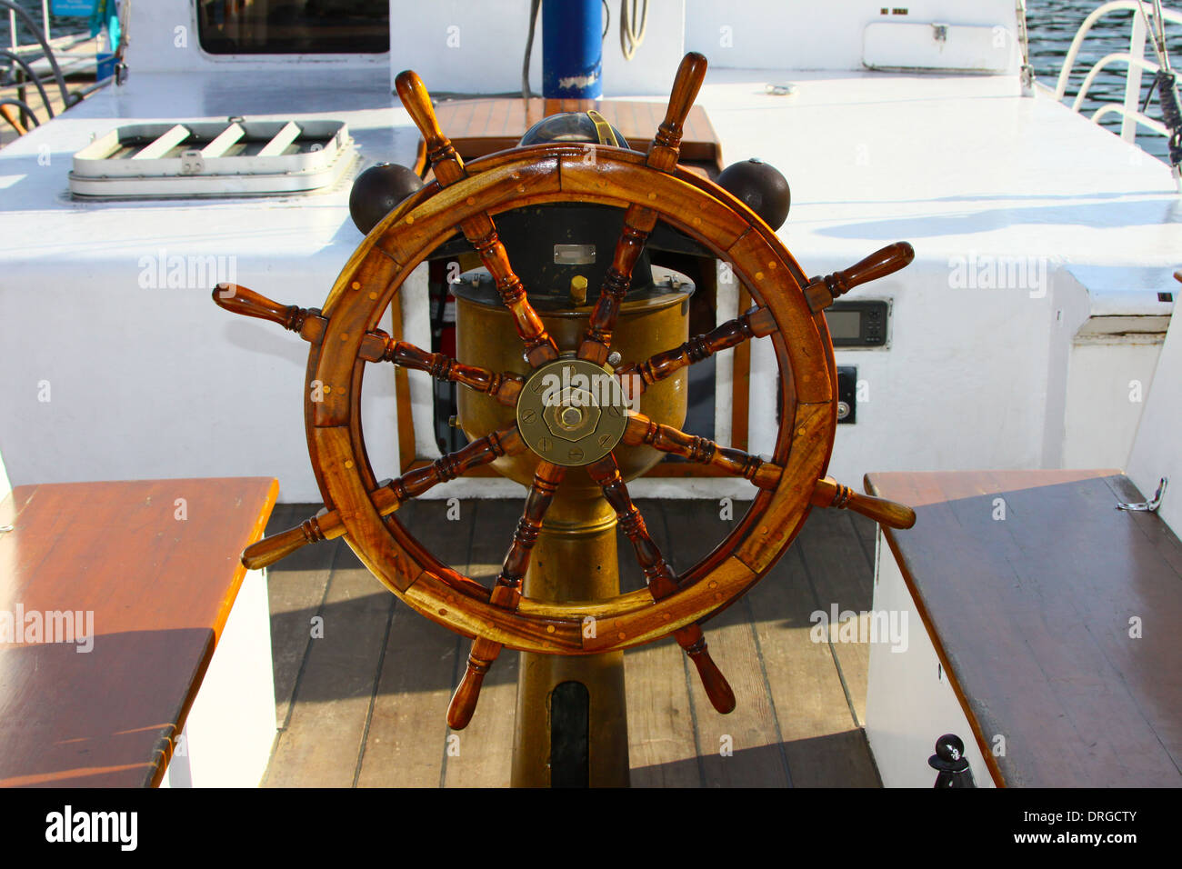 Vintage wooden steering wheel and navigation compass on a tall sailing ...