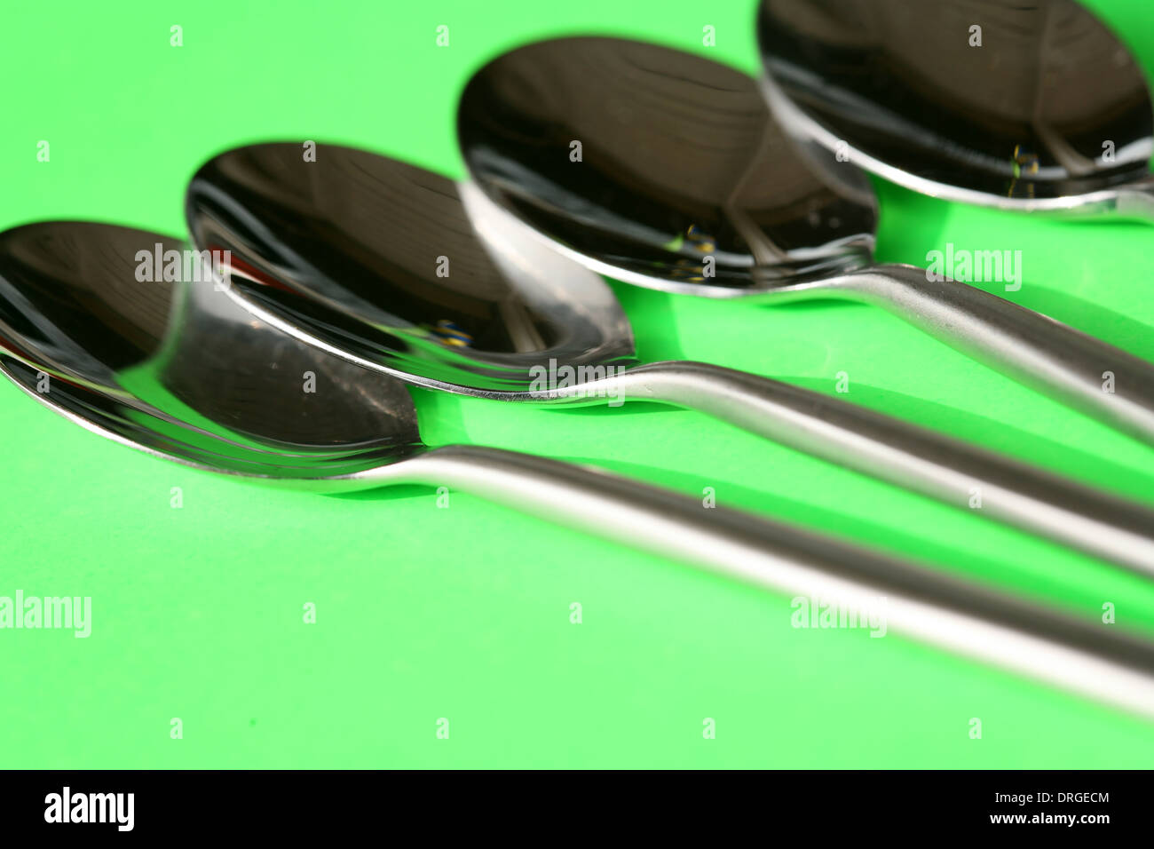 spoons against a green background Stock Photo - Alamy