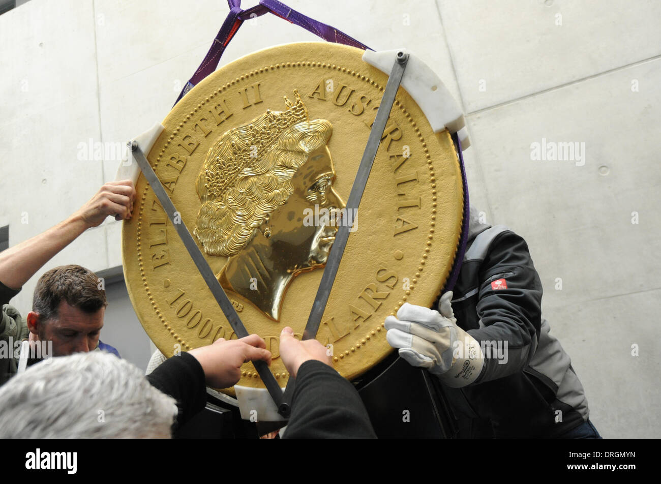 Munich, Germany. 26th Jan, 2014. Employees put the biggest gold coin of ...