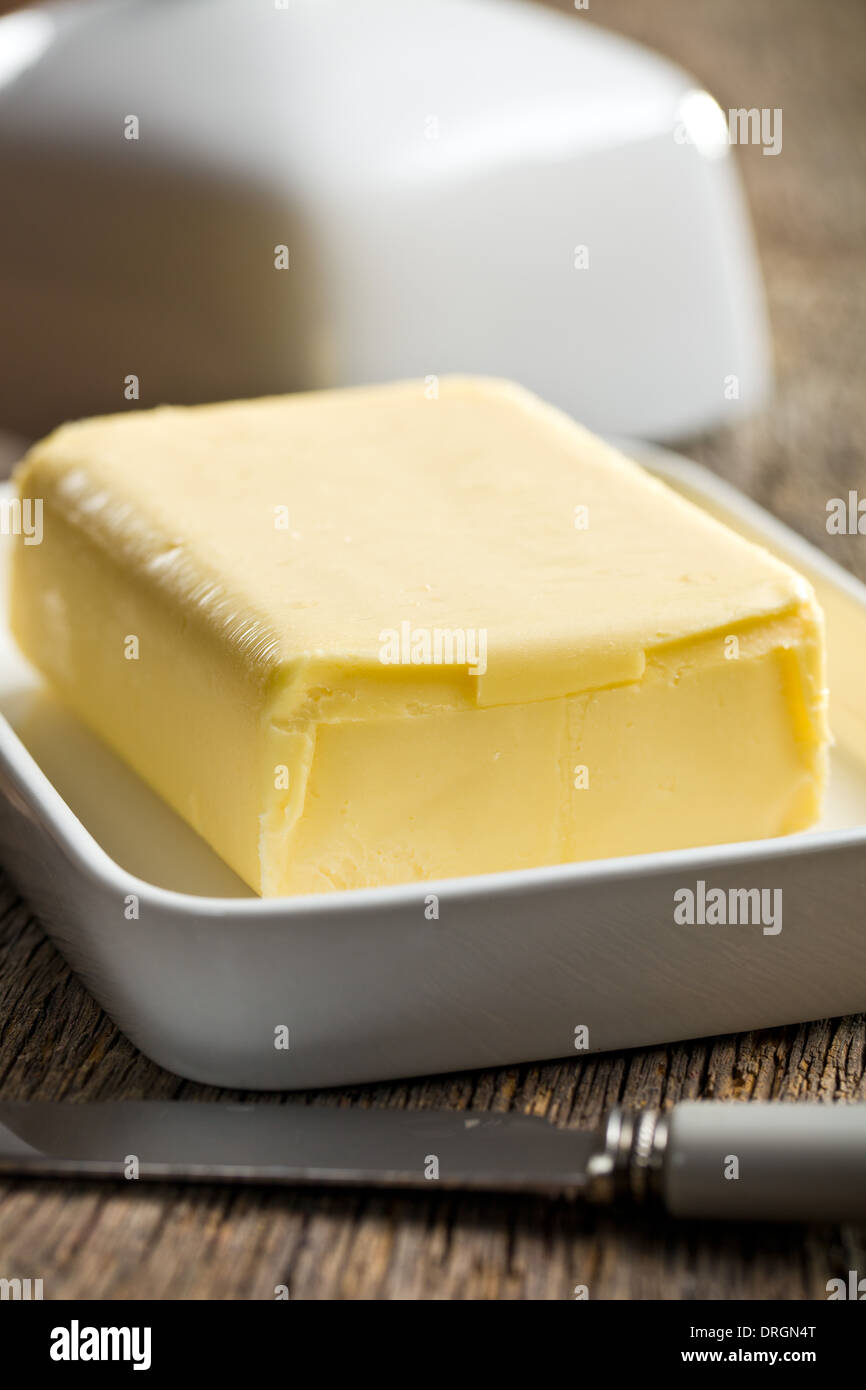 cube of butter with knife on wooden background Stock Photo - Alamy