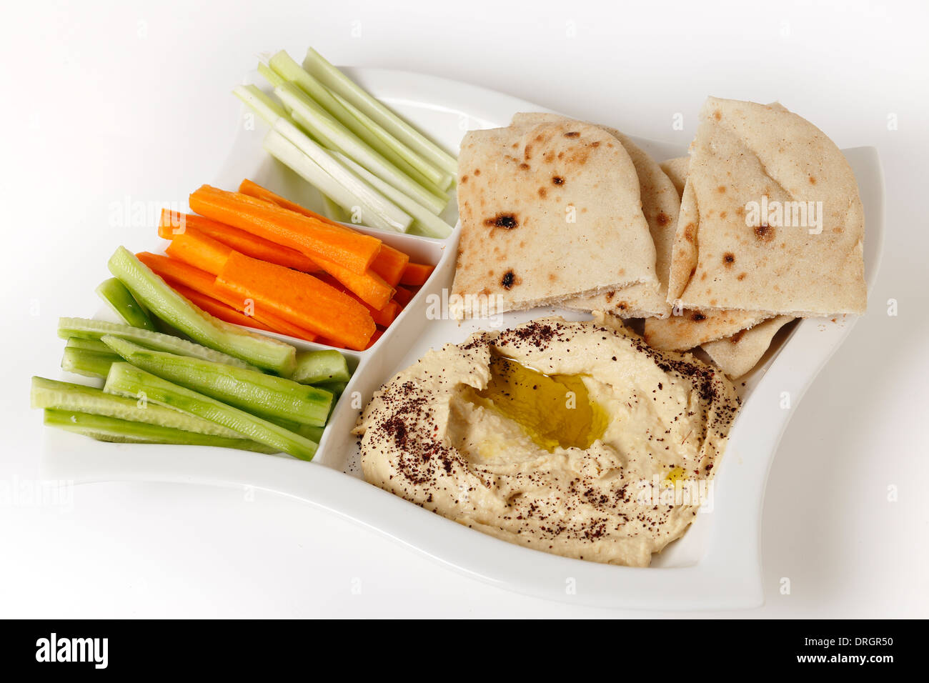 High angle view of a dip tray with hummus, bread, carrot sticks, celery ...