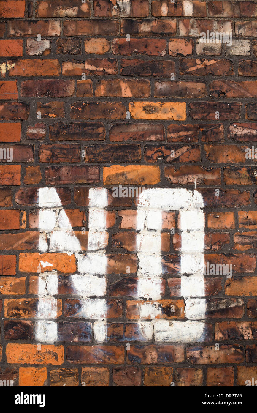 'NO' written on brick wall with white paint Stock Photo - Alamy
