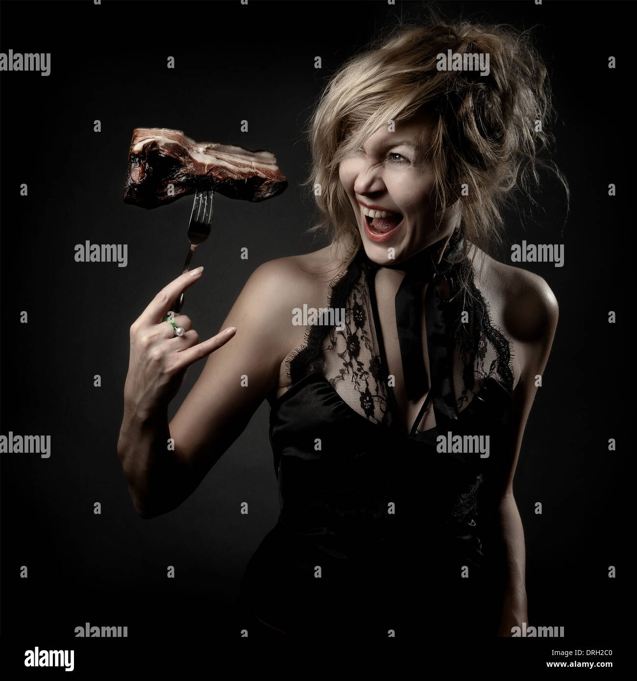 hungry predator woman biting meat Stock Photo - Alamy