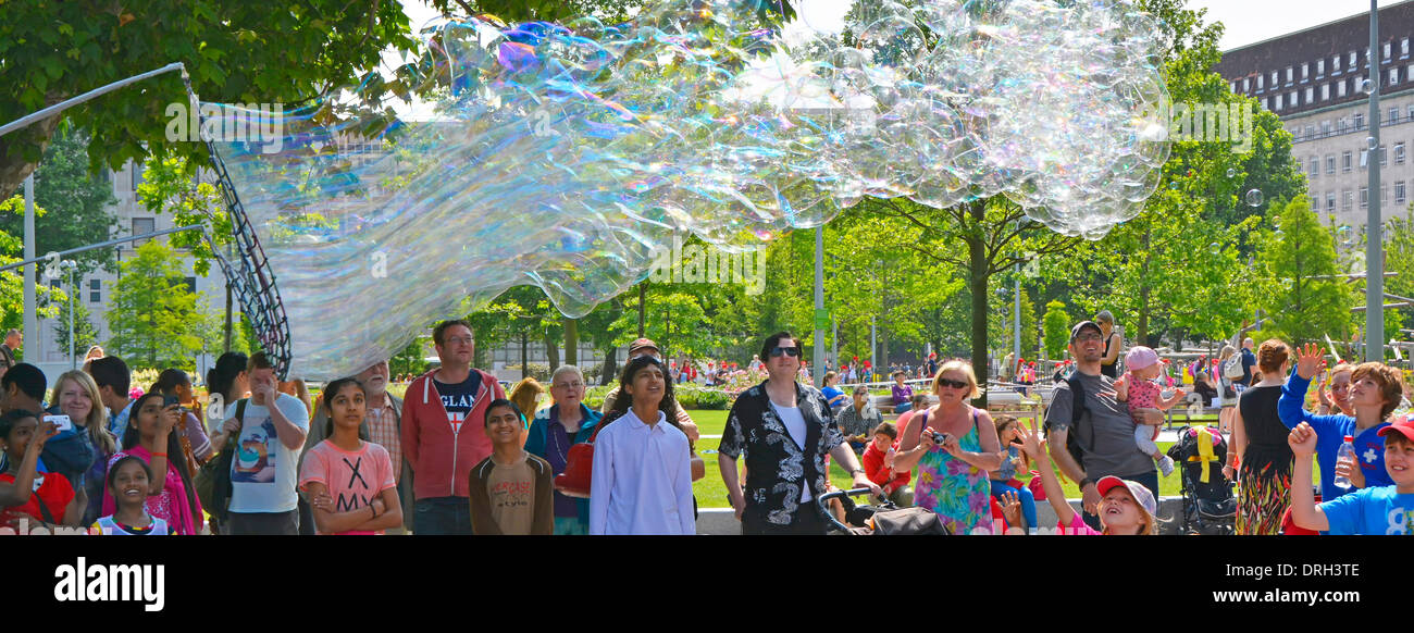 Families enjoying a demonstration of big bubble creations using a large ...
