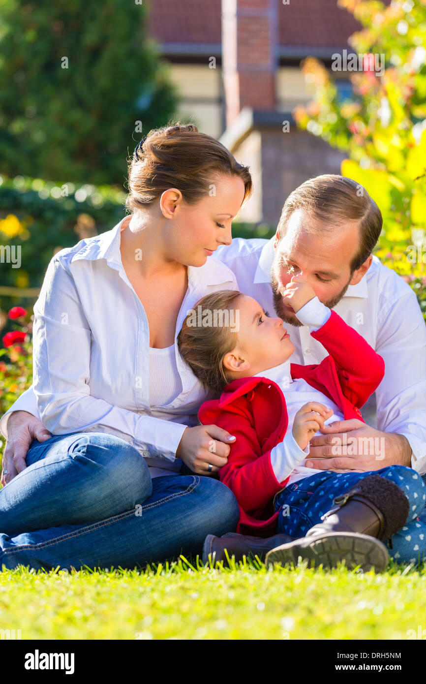 Family with mother, father and daughter together in the garden meadow ...