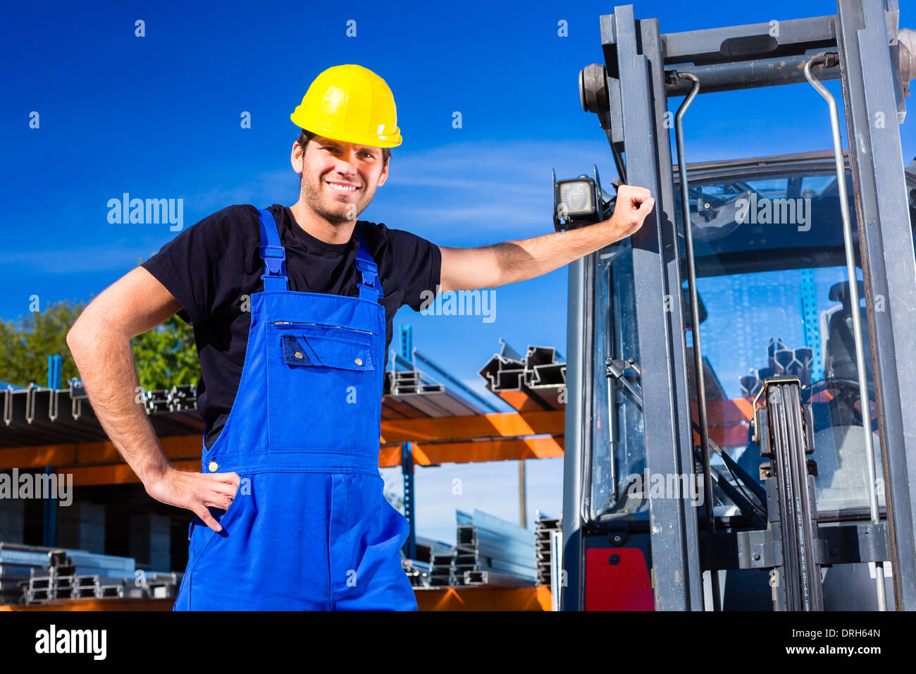 builder or driver with pallet transporter or lift fork truck on ...