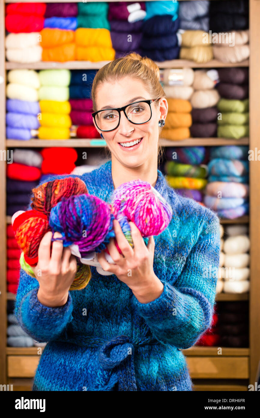 Young woman buying colorful wool and yarn for their hobby in a knitting ...