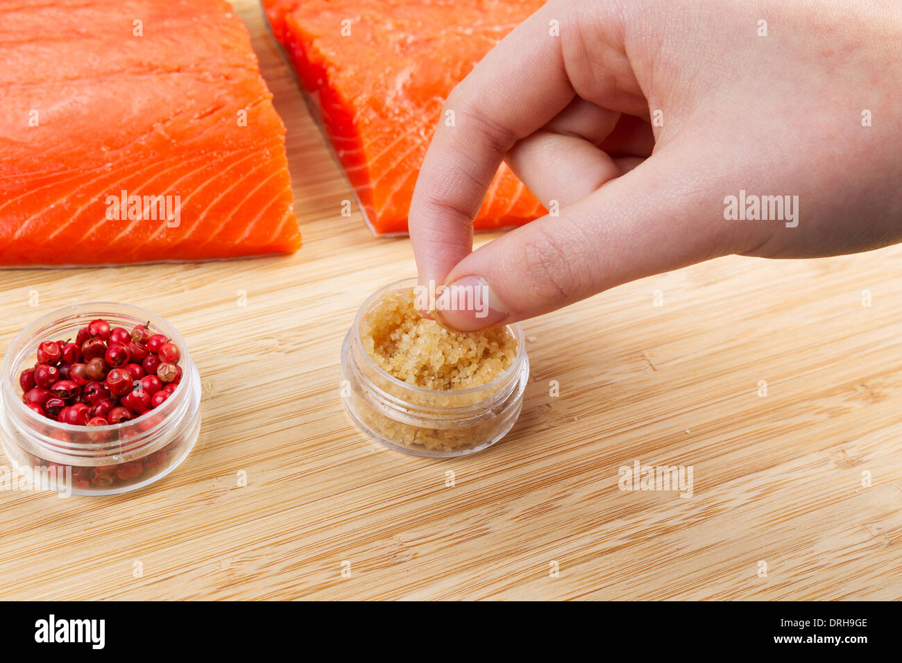 Horizontal photo of female fingers pinching sea salt, from container ...