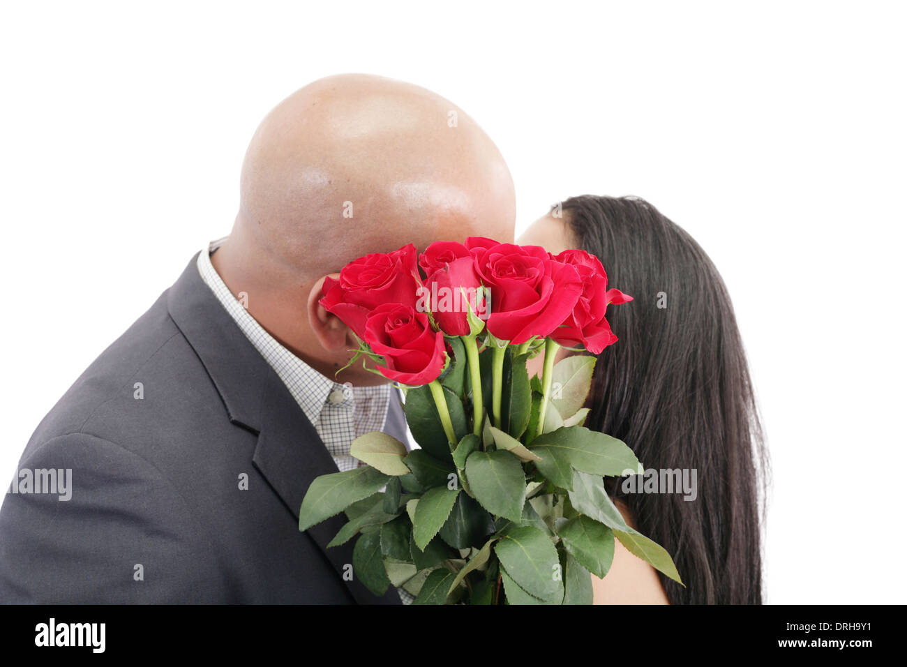 Two young dates kissing behind a bouquet of red roses Stock Photo - Alamy