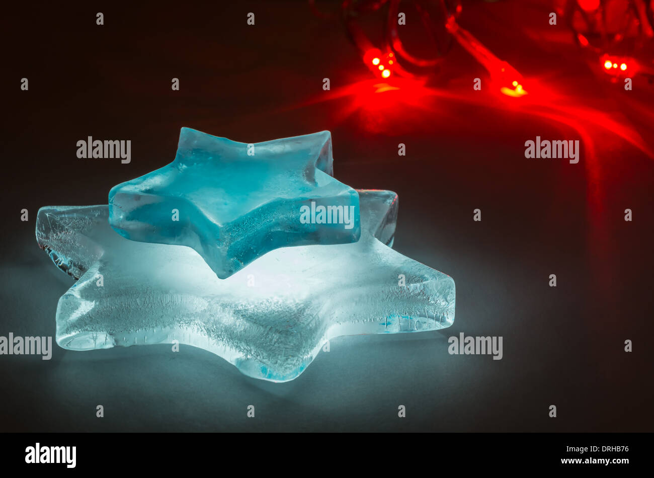 A star-shaped ice cube glowing brightly, Christmas decoration lights in ...