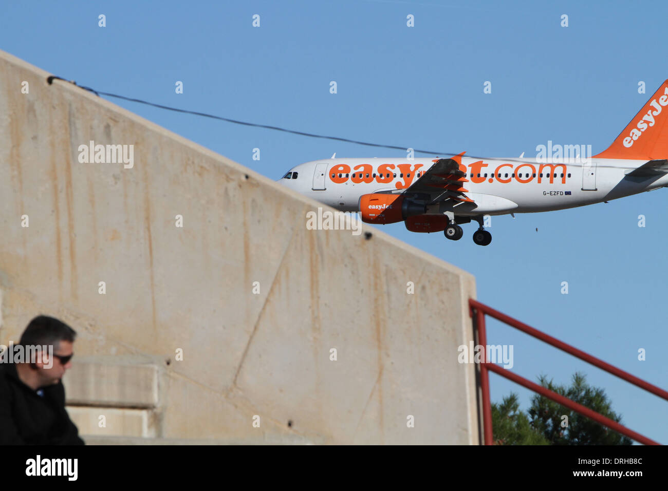 Low flying plane over building easy jet Stock Photo - Alamy