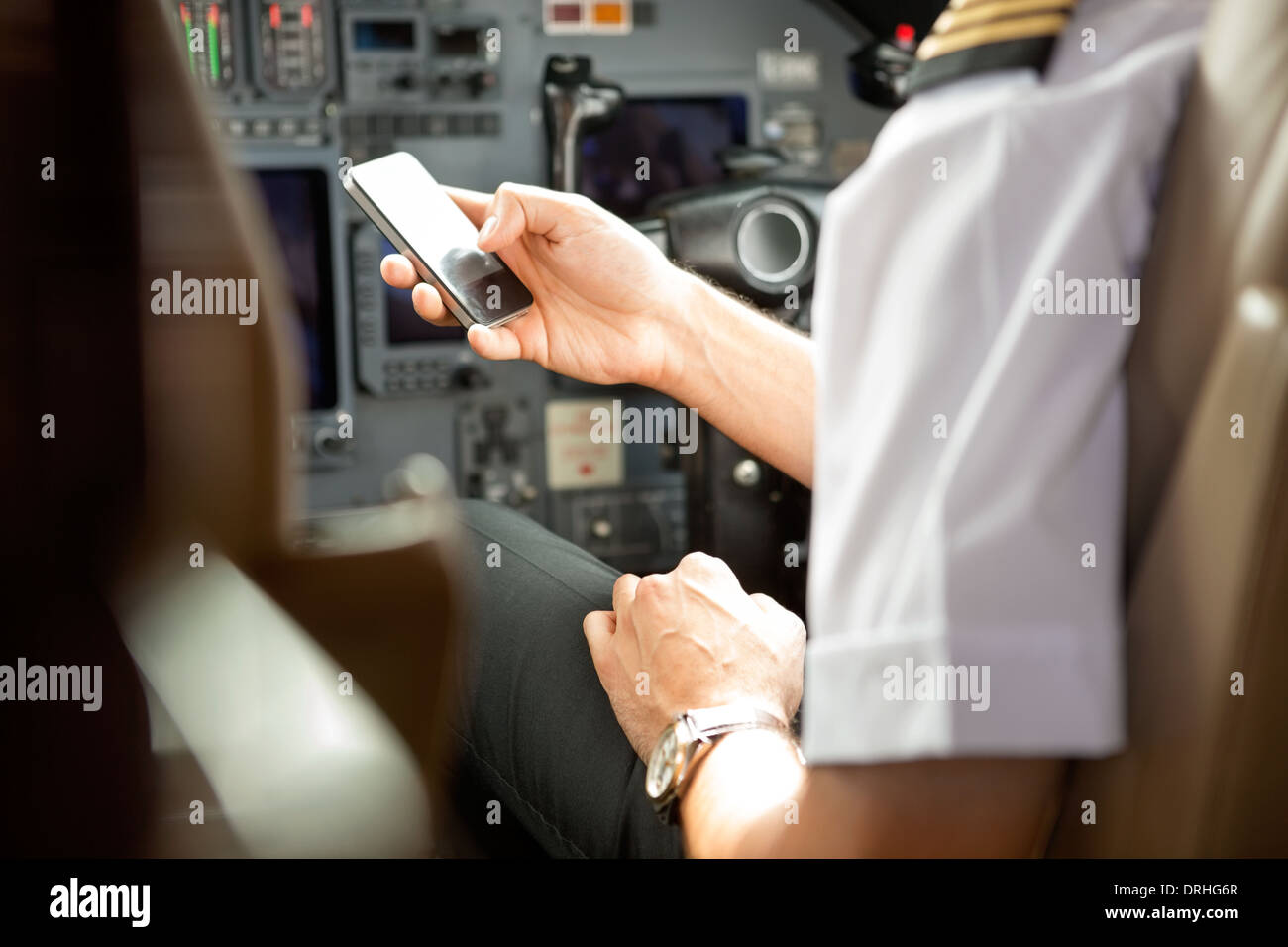 Pilot Using Cell Phone In Cockpit Stock Photo - Alamy