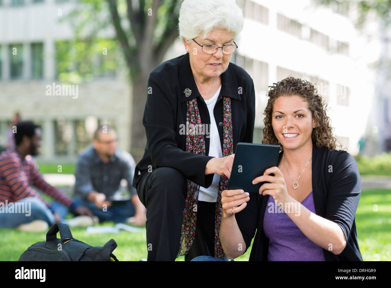 Female University Student Using Digital Tablet With Friend Stock Photo ...