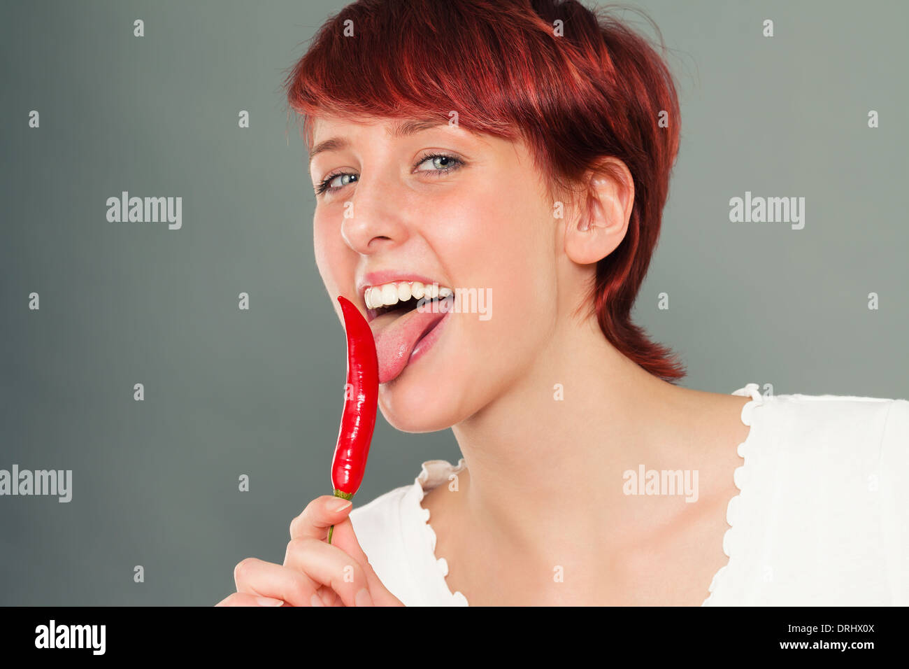 happy redhead woman licking on a spicy pepperoni Stock Photo - Alamy